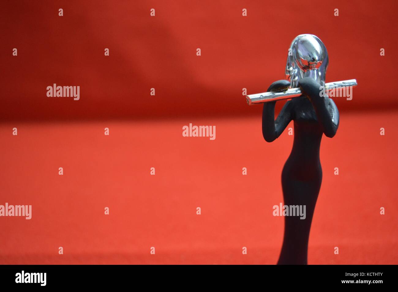 Toy woman flute on red background Stock Photo - Alamy