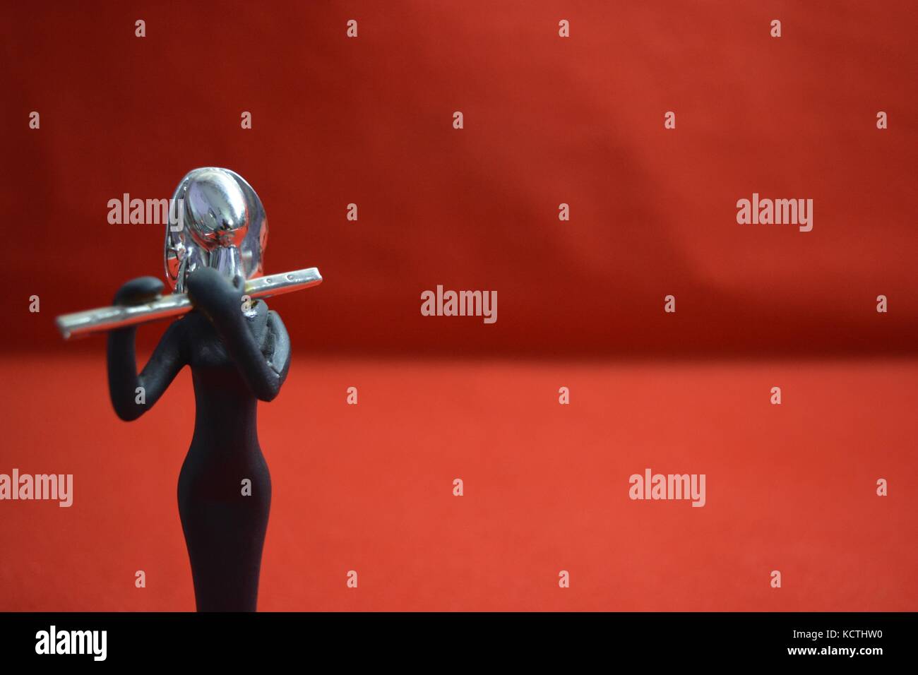 Toy woman flute on red background Stock Photo - Alamy