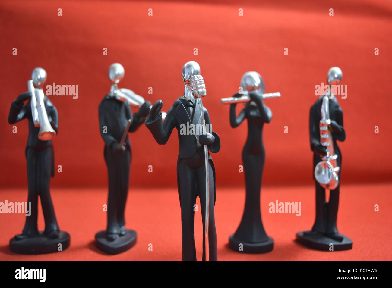 Toy man with microphone and musicians on the red background Stock Photo ...