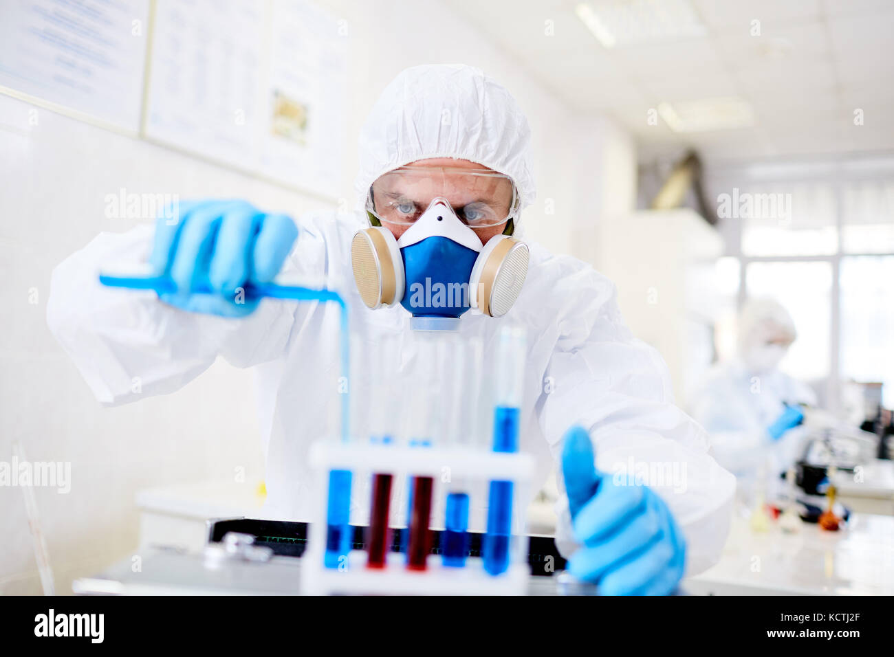 Hard-working virology research scientist wearing hazmat suit developing ...