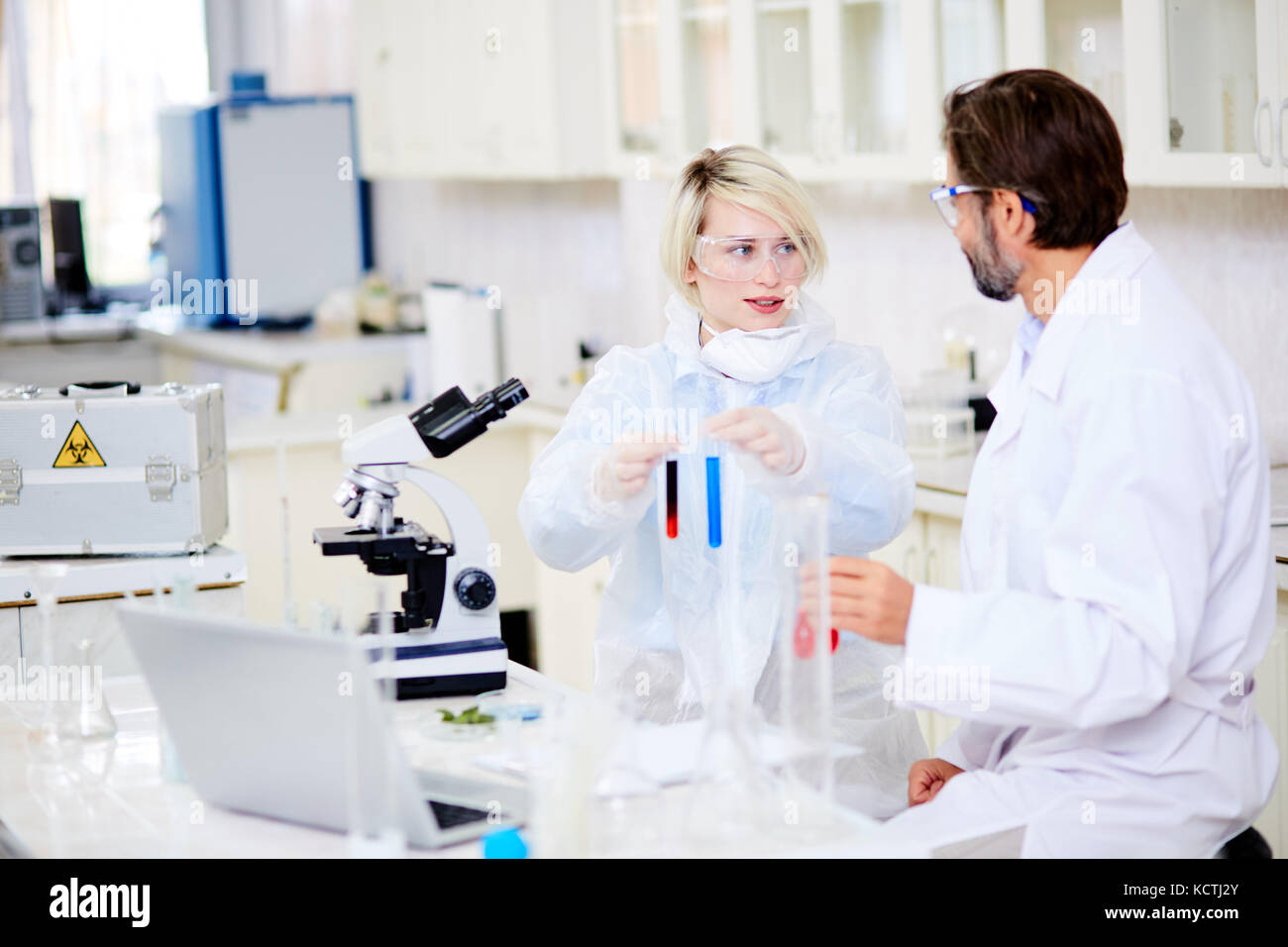 Group of talented microbiologists wearing safety goggles discussing ...
