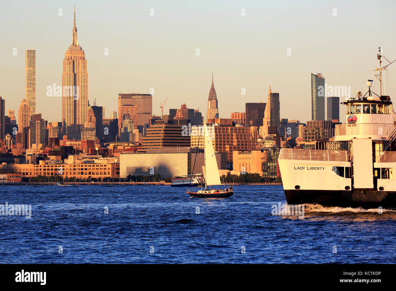 Lady Liberty ferry in Hudson River with skyline of midtown Manhattan ...