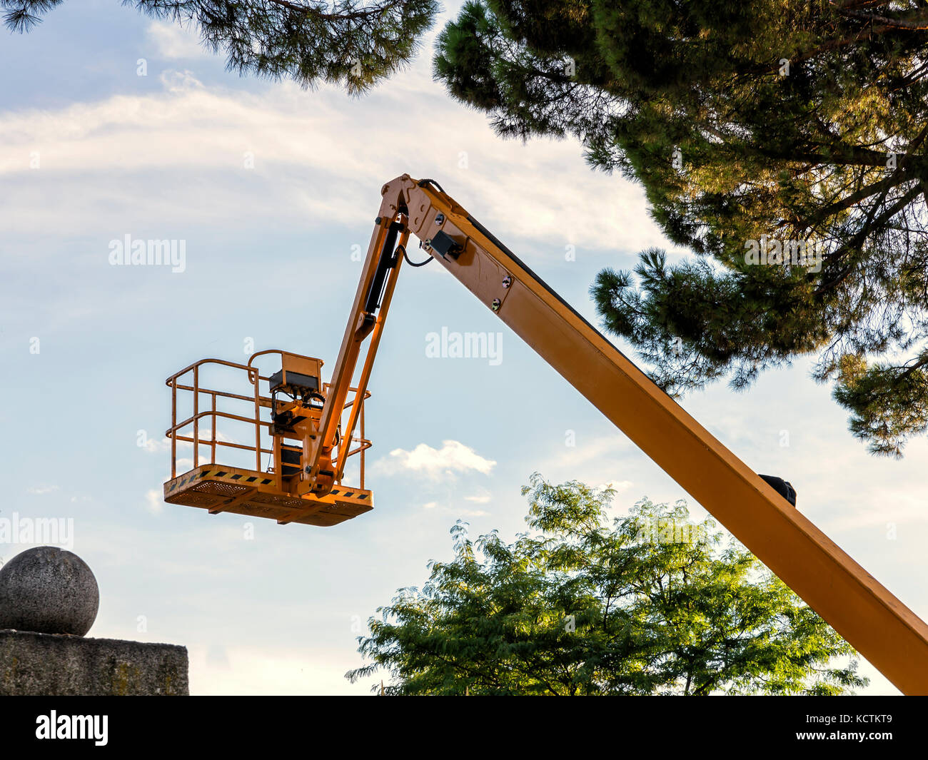 yellow platform lift in the forest to prune trees Stock Photo - Alamy