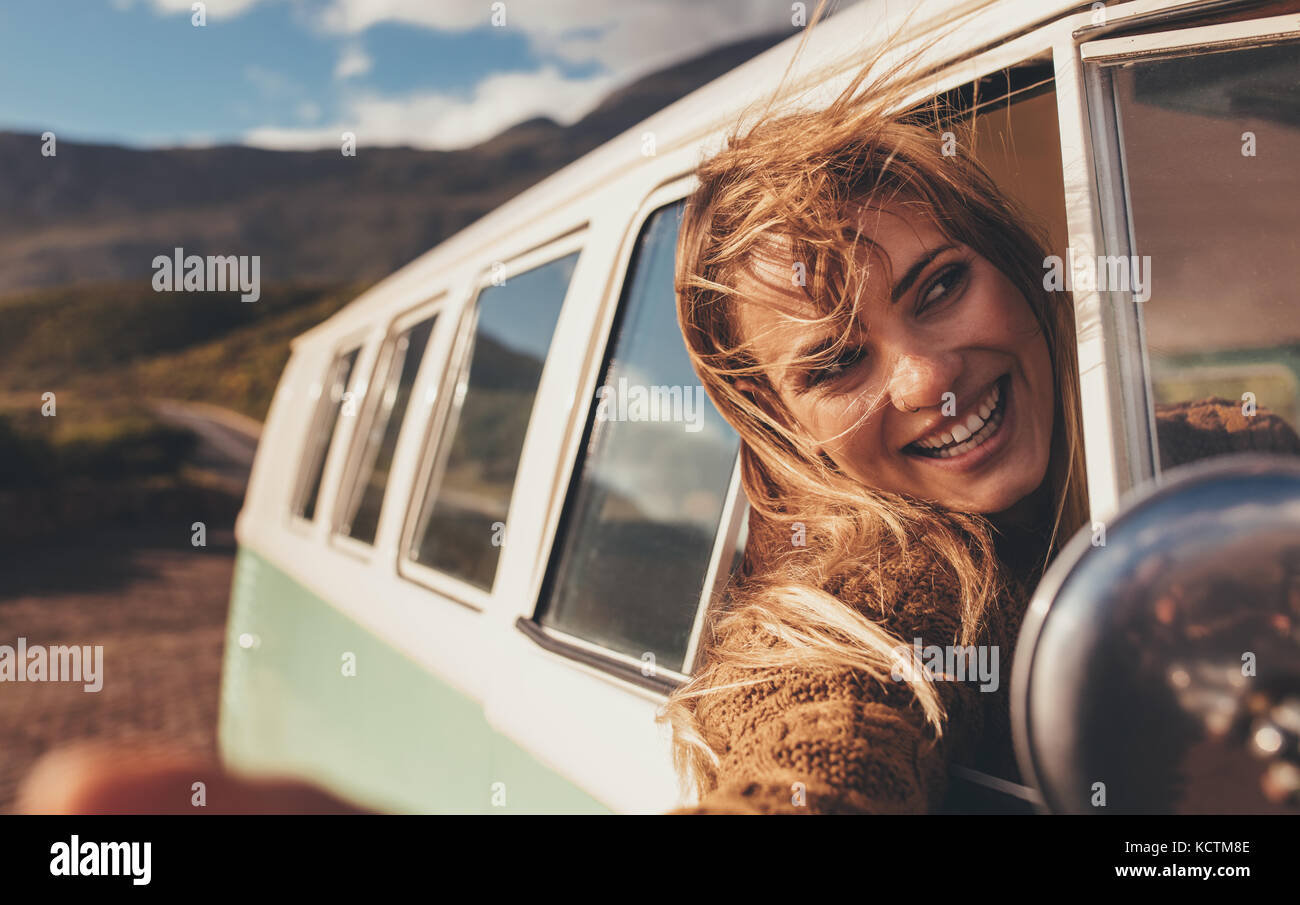 Happy woman on road trip driving a van and laughing. Smiling caucasian ...