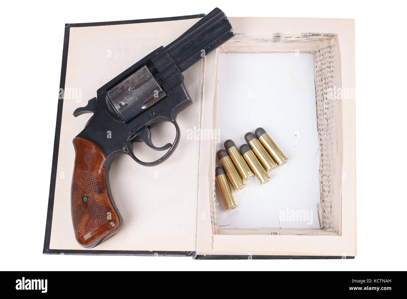 Revolver gun with cartridges hidden in a book Stock Photo - Alamy