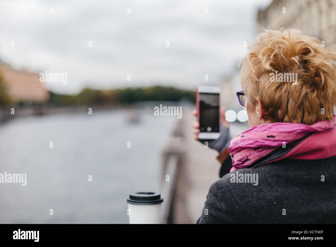 Woman taking shots from waterfront Stock Photo - Alamy