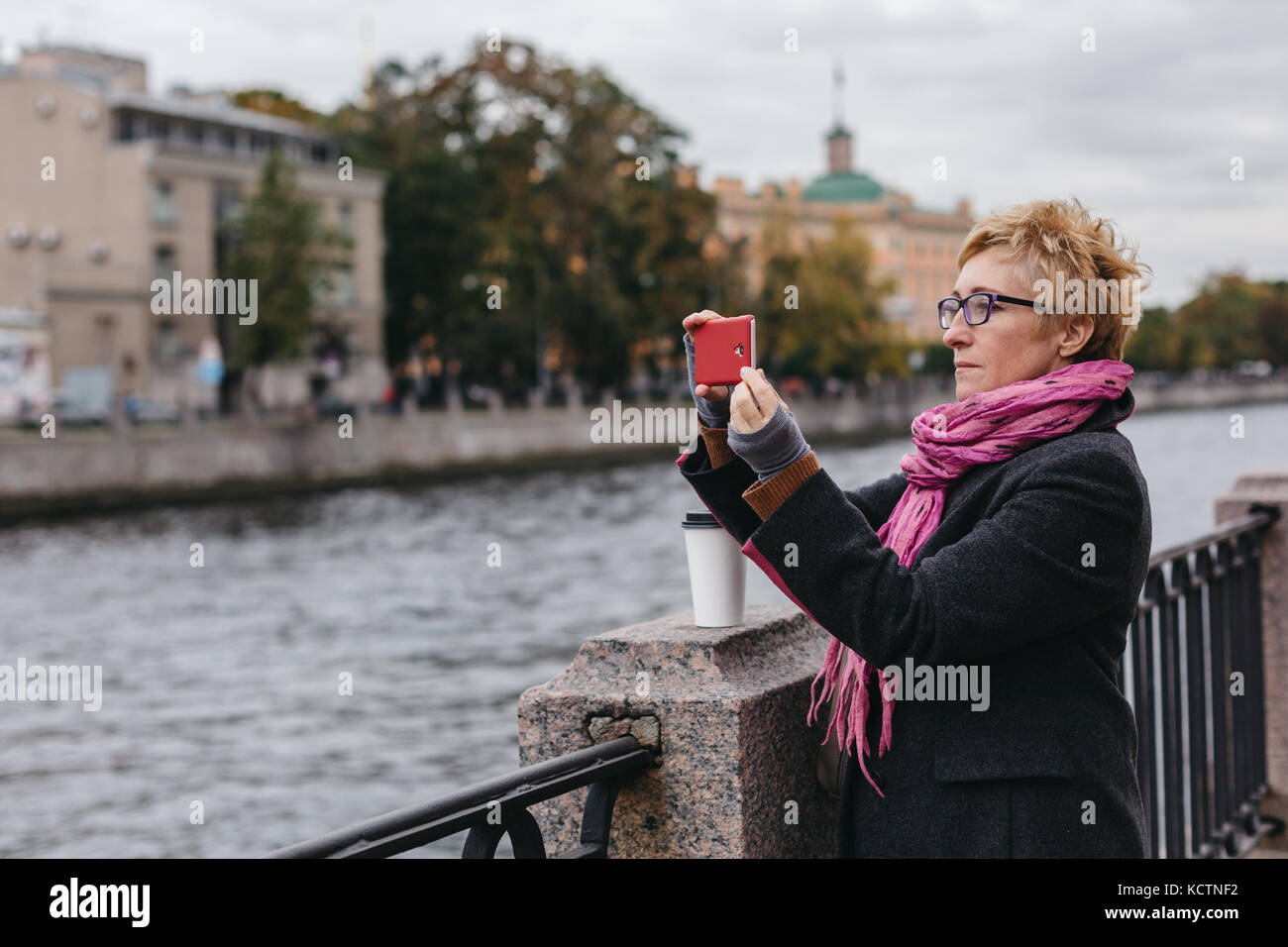 Woman taking shots on waterfront Stock Photo - Alamy