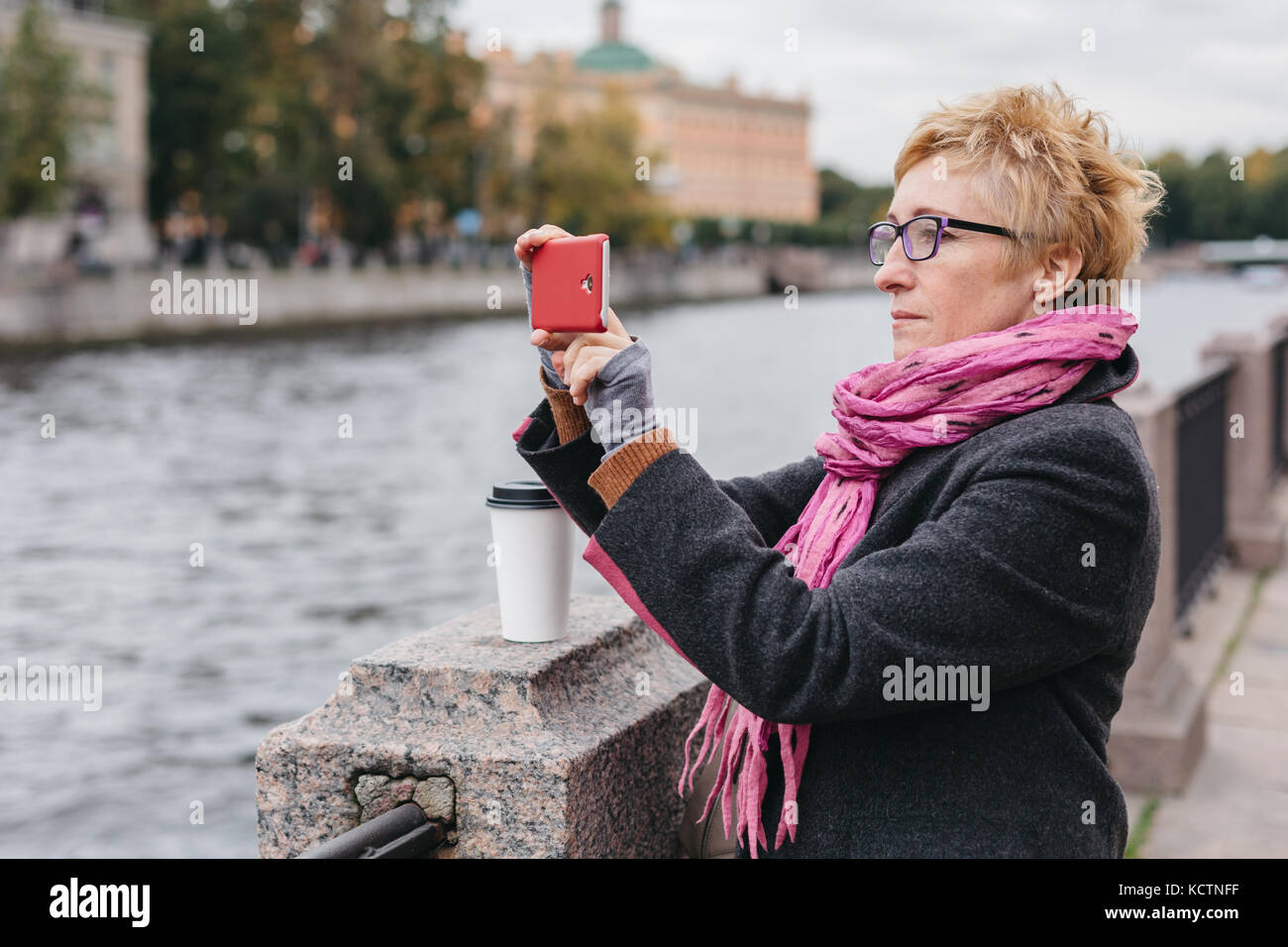 Woman taking shots on waterfront Stock Photo - Alamy