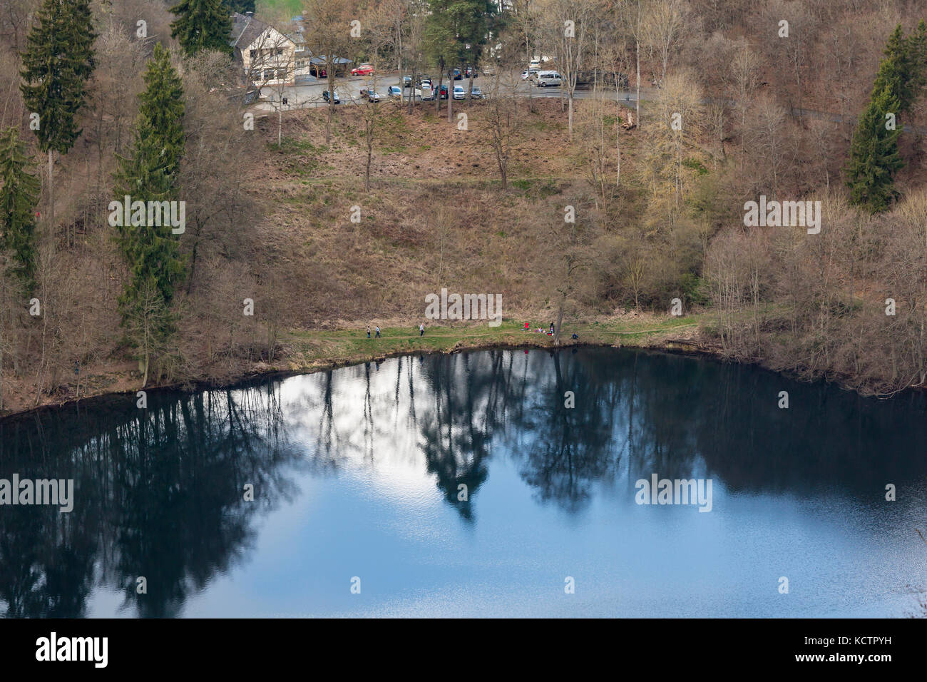 People at the Gemuendener Maar volcano lake in the Eifel, Germany near ...