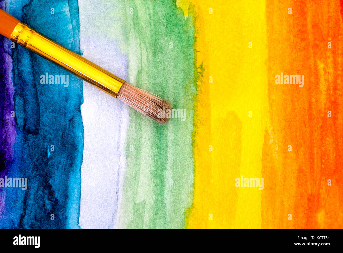 Paintbrush on rainbow watercolour hand drawing backgrounds. Close-up ...