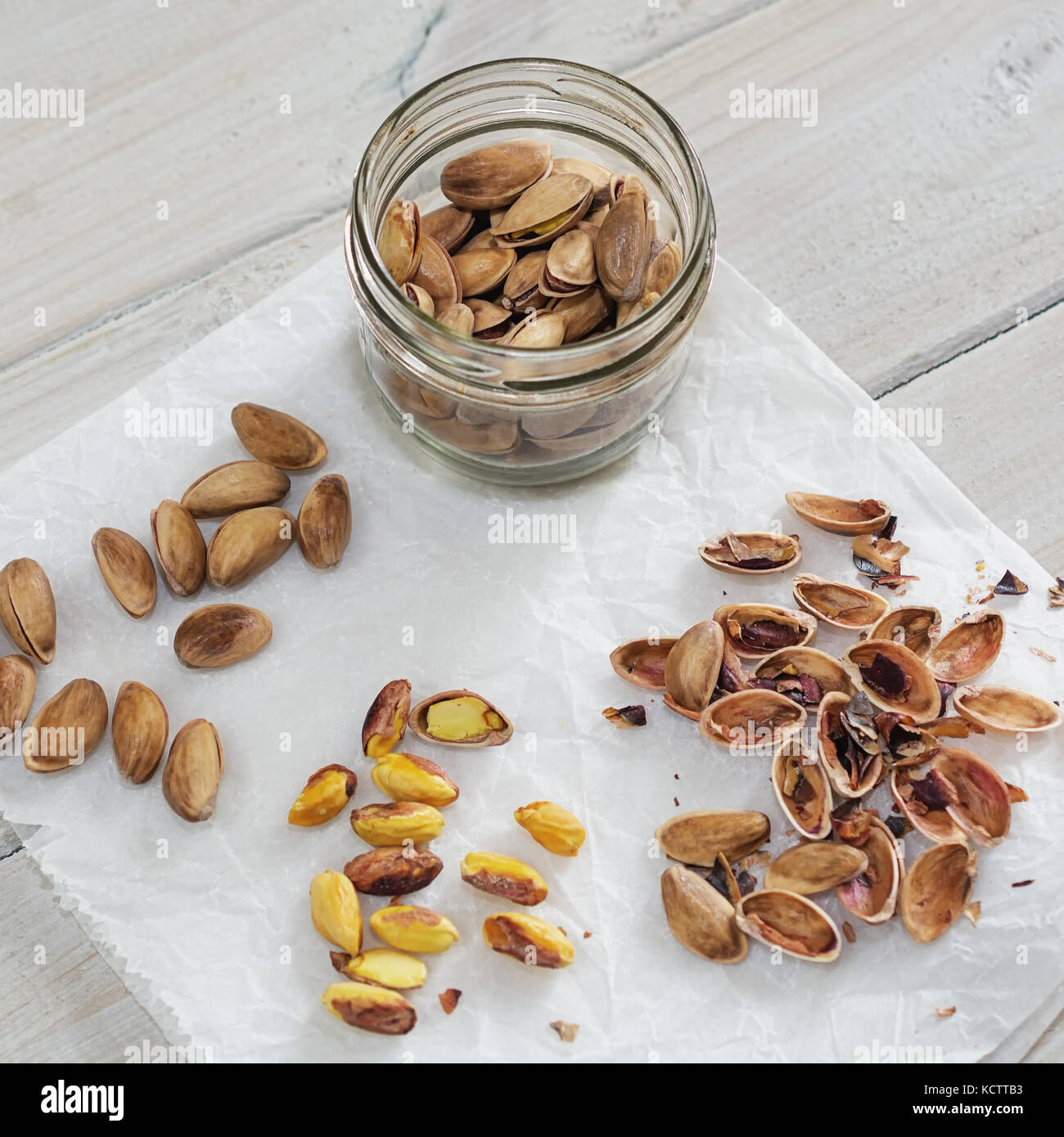 Peeled and unpeeled pistachio nuts presented on a white napkin Stock ...