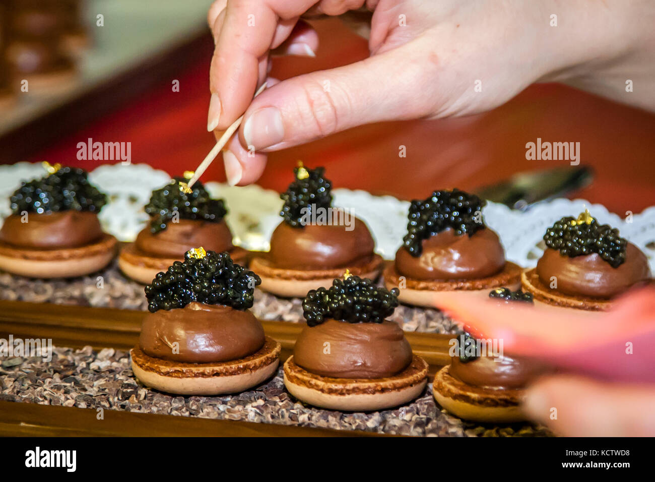 Caviar decorated with gold leaf on the chocolate praline. Dessert from ...