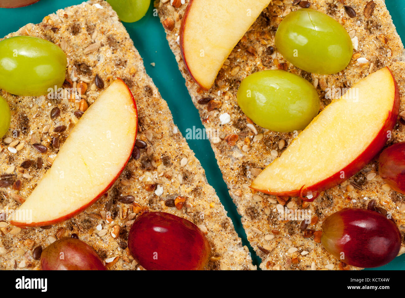 Close up shot of apple segments and grapes arranged on slices of ...
