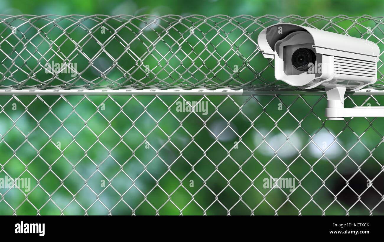 Security surveillance camera on chain-link fence on abstract nature ...