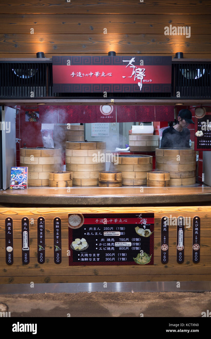 Night shot of traditional steamed bun counter with steam rising from ...