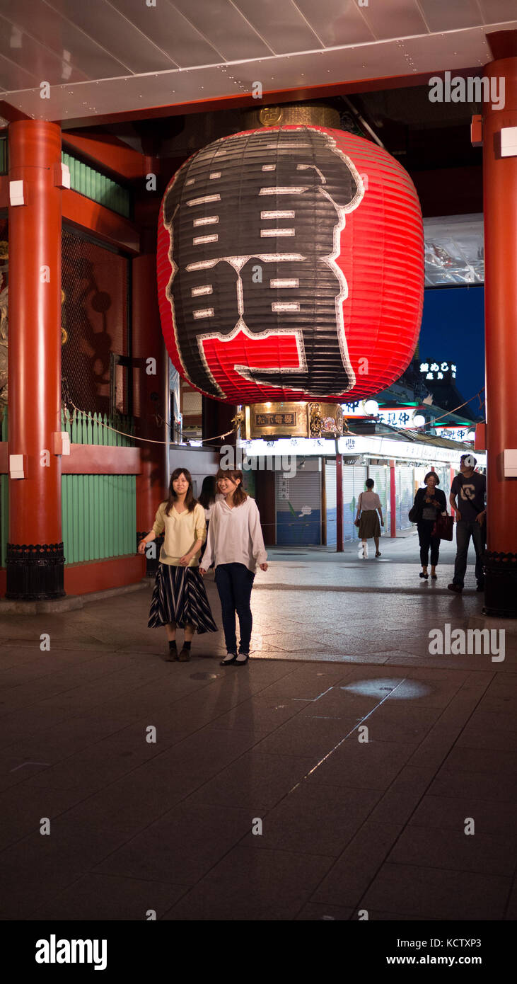 Young Japanese women posing under Homozon Gate red lantern at night at ...