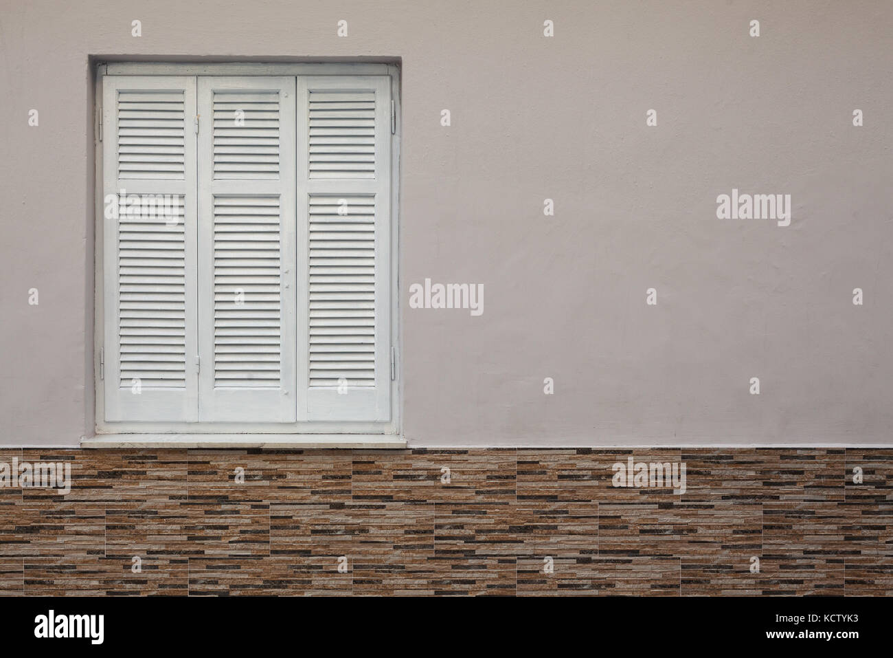 White closed window in house wall, details of wall decoration and old ...