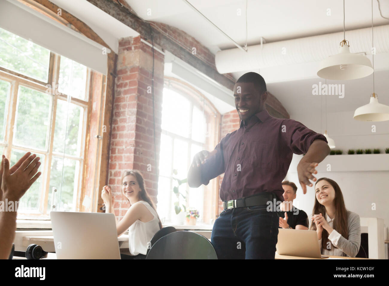 African american office worker dancing surrounded by coworkers. Happy ...