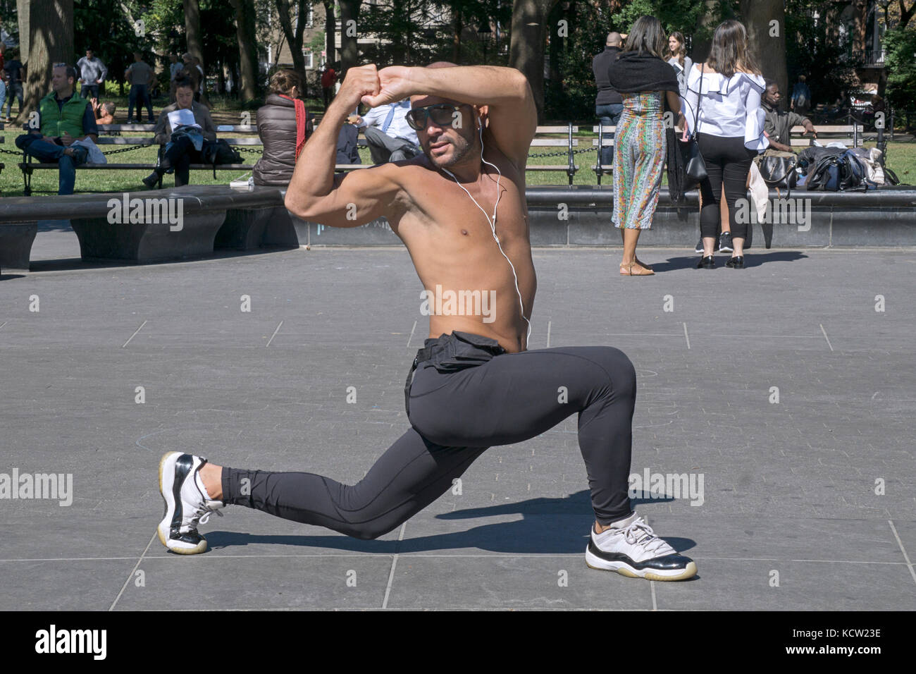 A fit man stretching and exercising outdoors shirtless in Washington ...