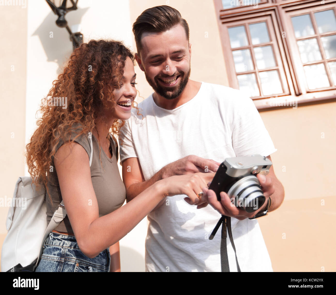 Portrait of young friends walking looking at the photos Stock Photo - Alamy