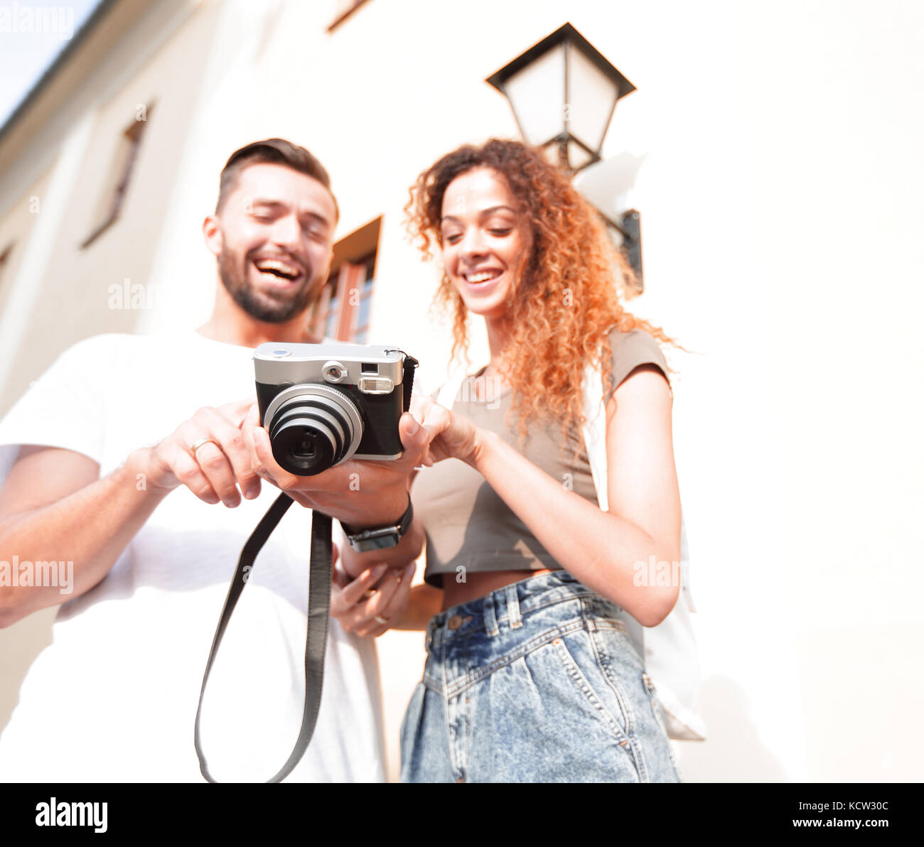 Portrait of young friends walking looking at the photos Stock Photo - Alamy