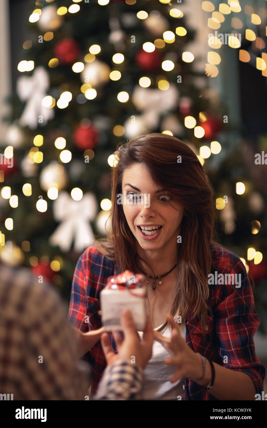 Very surprised and curious woman receiving Christmas gift from her ...
