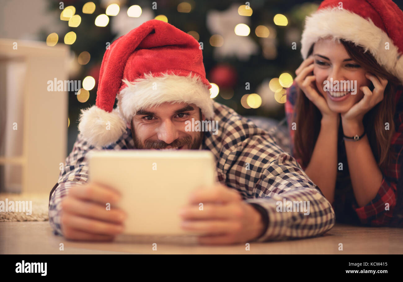 Young Christmas people celebrating holiday and looking on tablet Stock ...