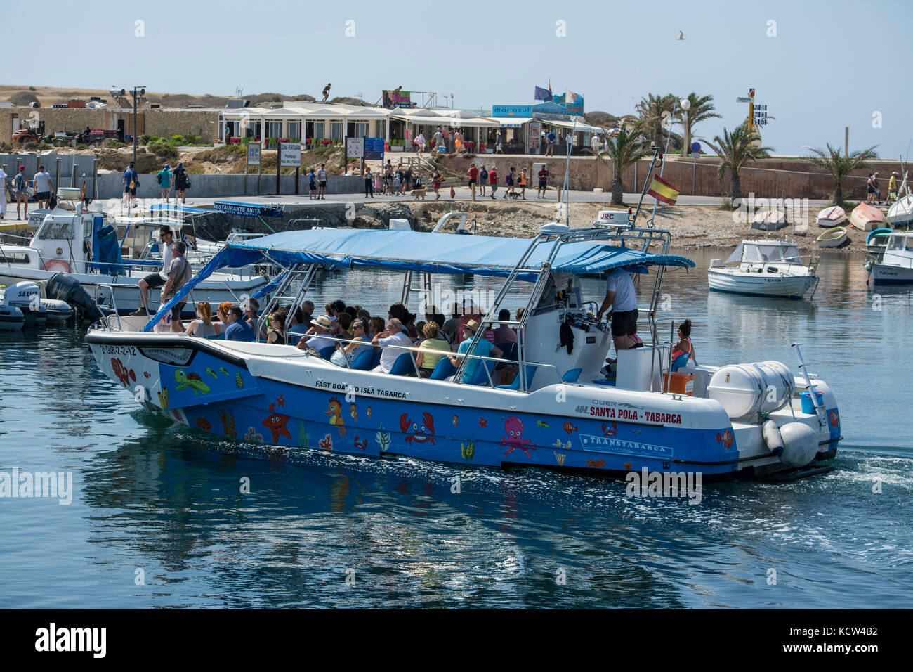 Tourists arrive from Santa Pola on a ferry boat at the harbour on the ...
