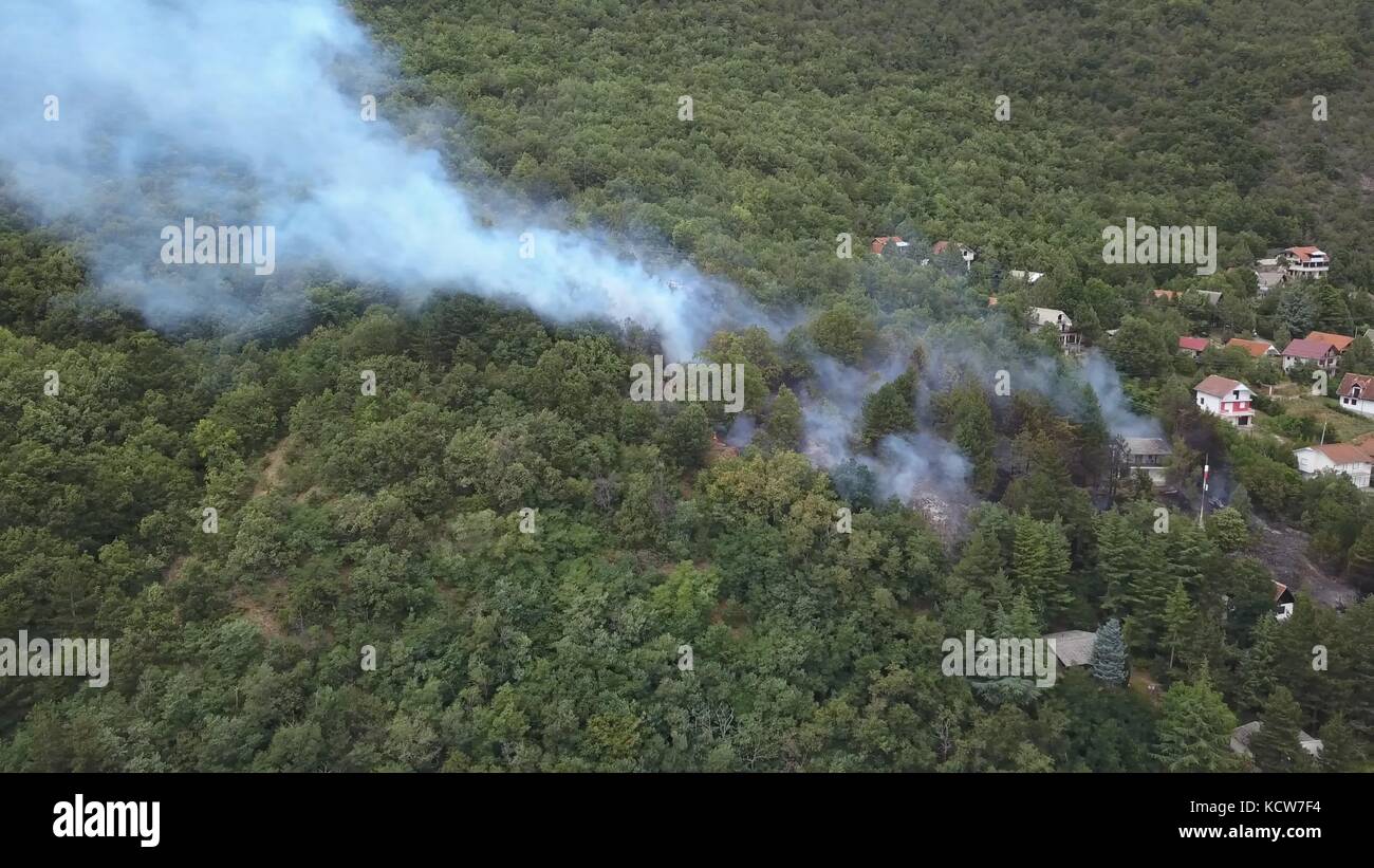 smoke of bush fire near village houses in macedonia,drone view Stock ...
