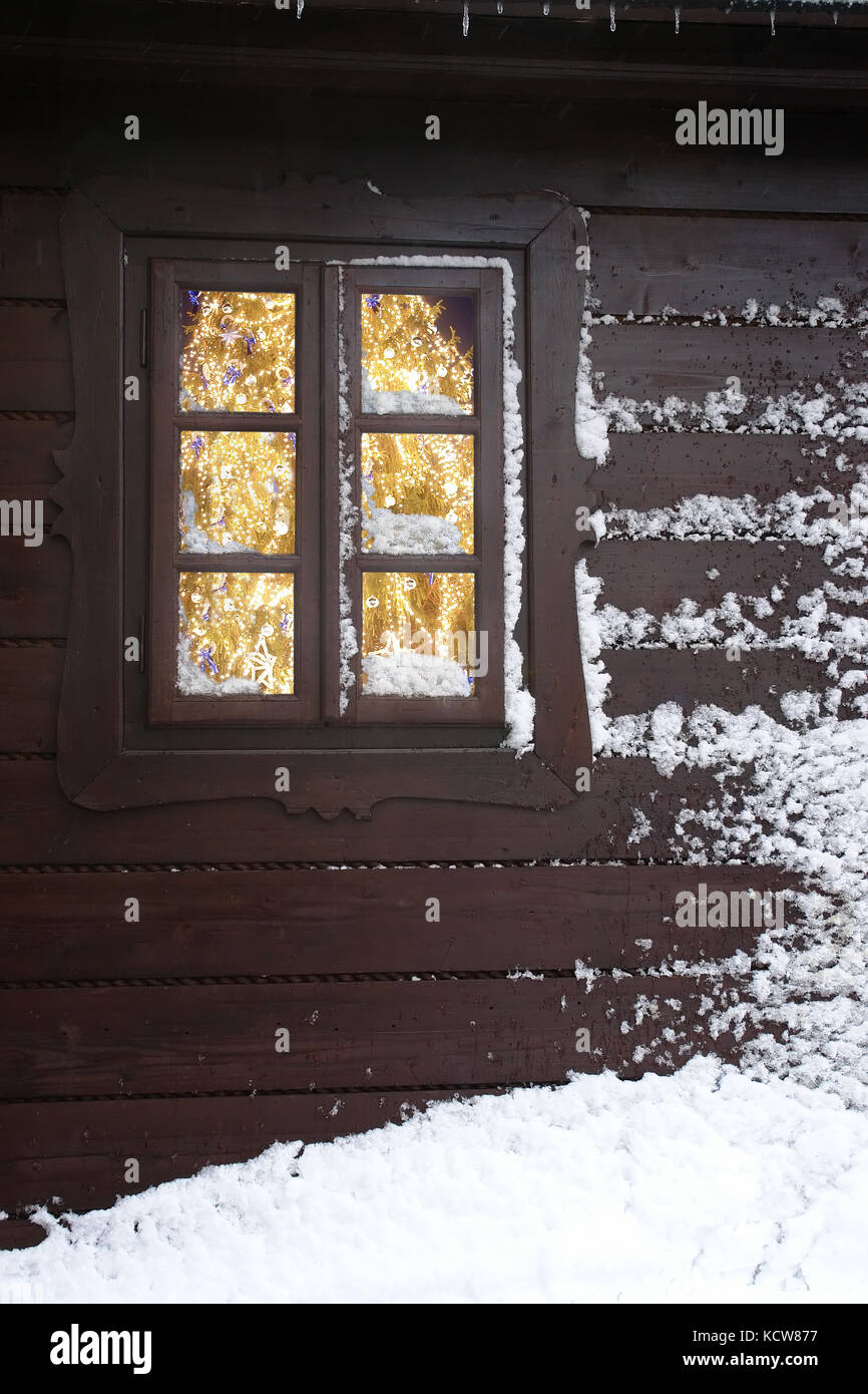 Christmas tree with lights seen through a wooden cabin window Stock ...