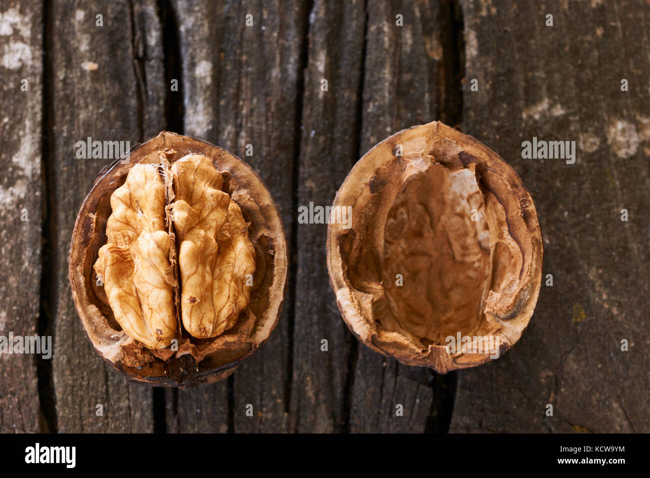 Two nuts, one open and one closed on an old wooden table Stock Photo ...