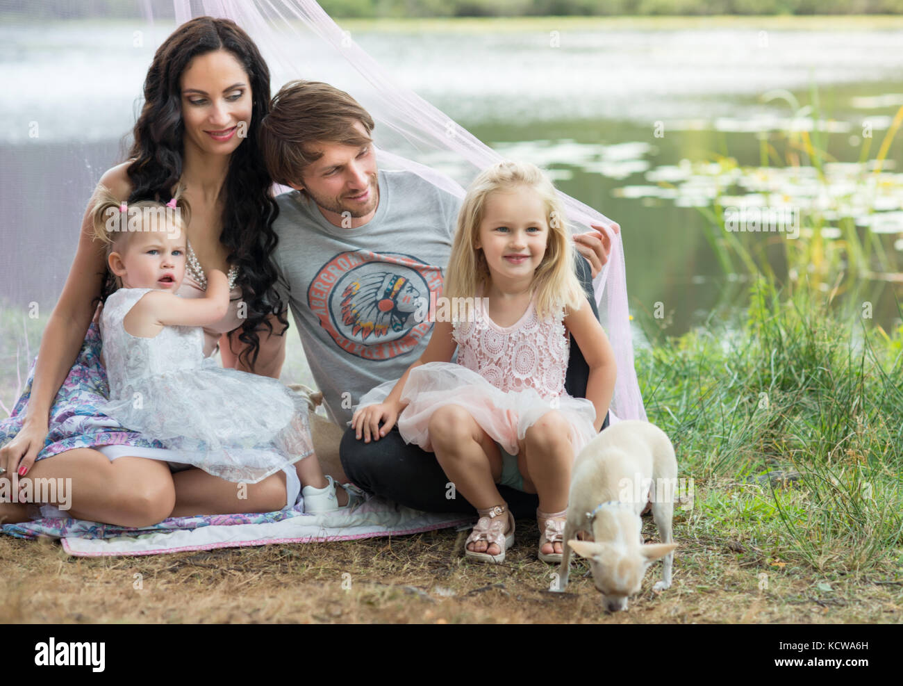 Beautiful young family with two daughters walking in the forest in ...