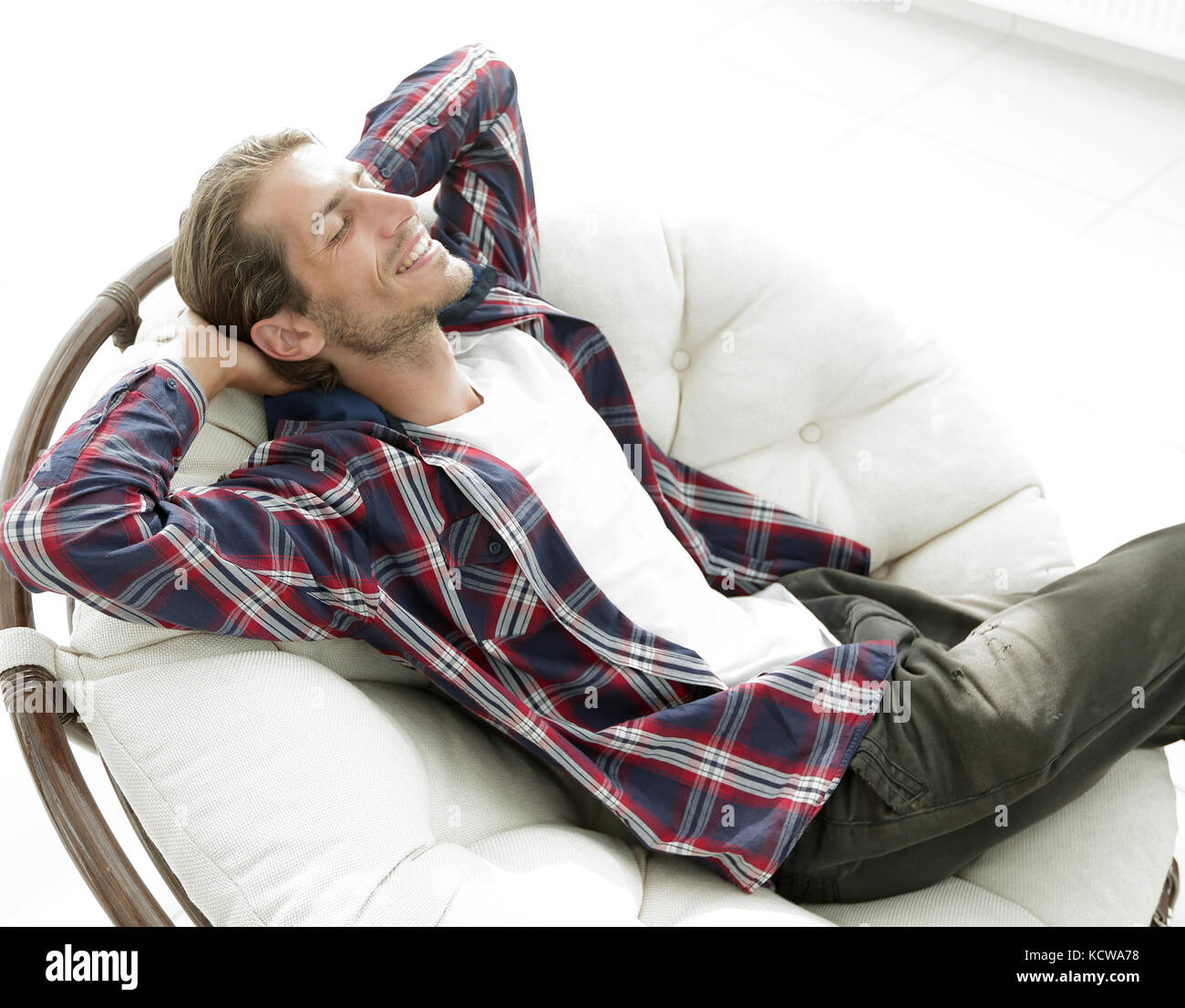 modern guy is resting sitting in a large comfortable chair. side view ...