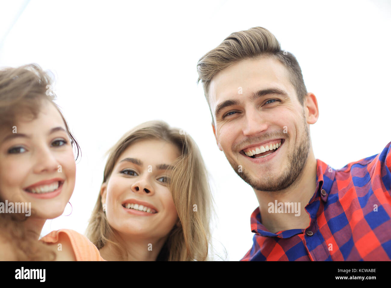 closeup of three young people smiling on white background Stock Photo ...