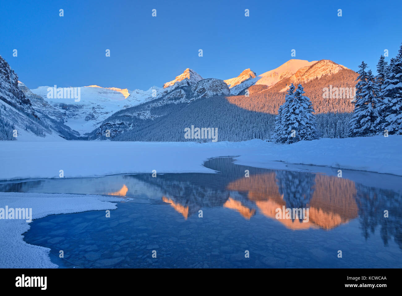 The Canadian Rocky Mountains reflected in Lake Louise at sunrise, Banff ...