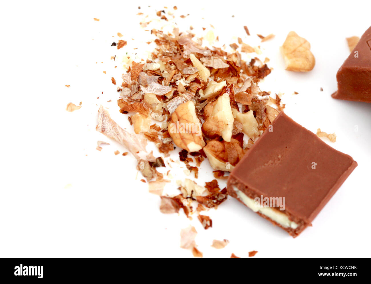 close up a stuffed chocolate bar and walnut pieces on white background ...