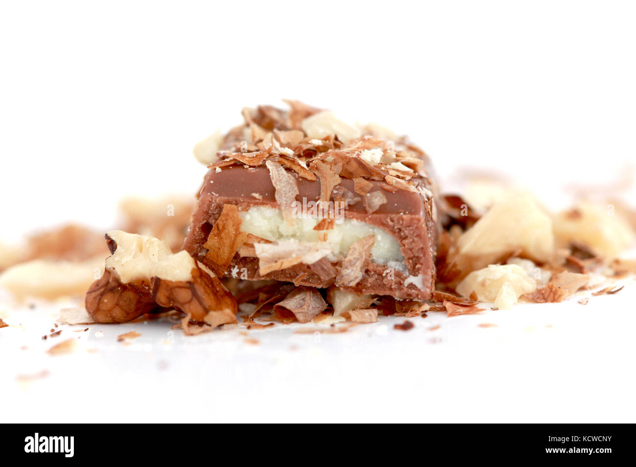 close up a stuffed chocolate bar and walnut pieces on white background ...