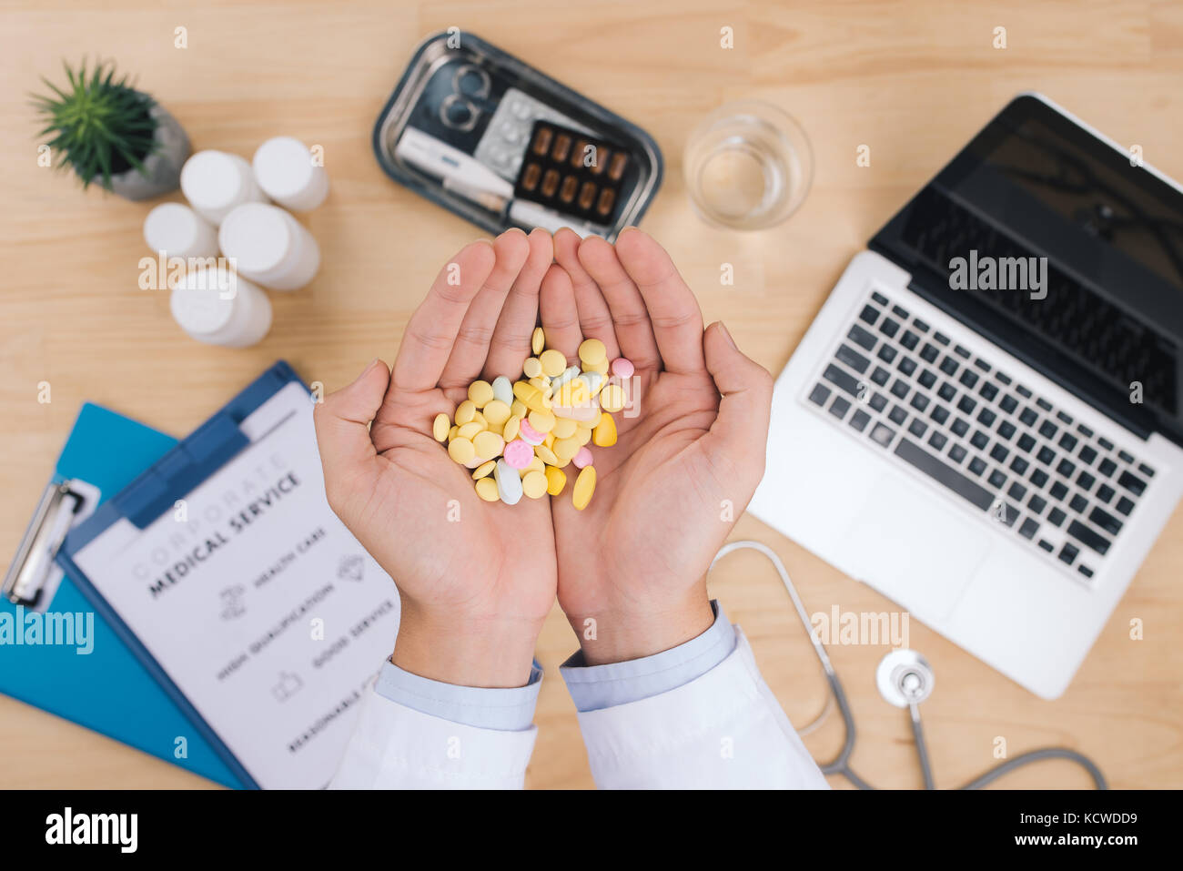 Pills in doctor hands over doctor desk table Stock Photo - Alamy