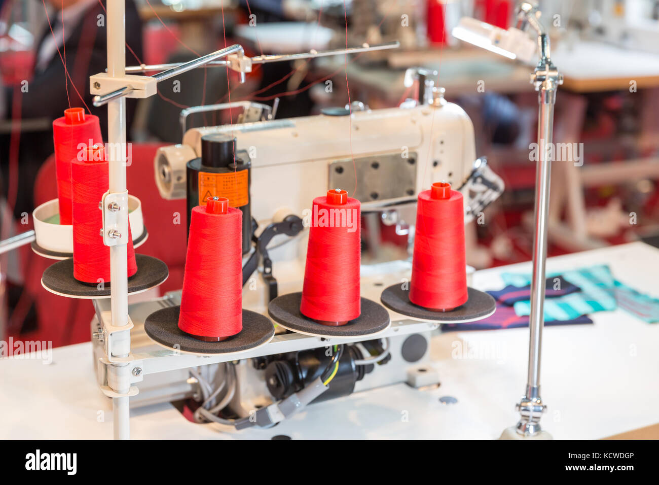 Spools of red threads on sewing machine. Cloth factory, weaving ...