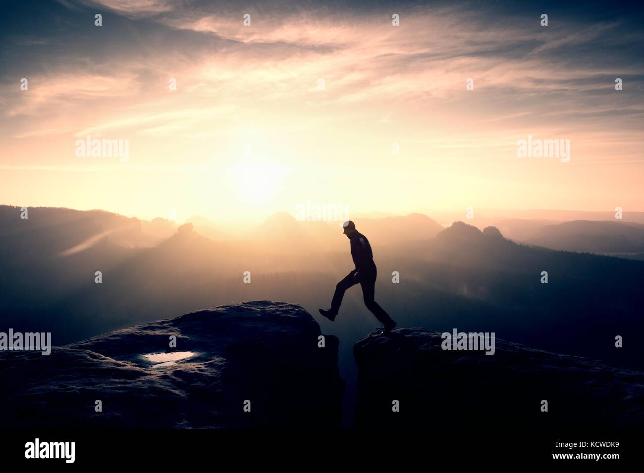 Crazy hiker umping between rocks. Marvelous colorful daybreak in rocky ...