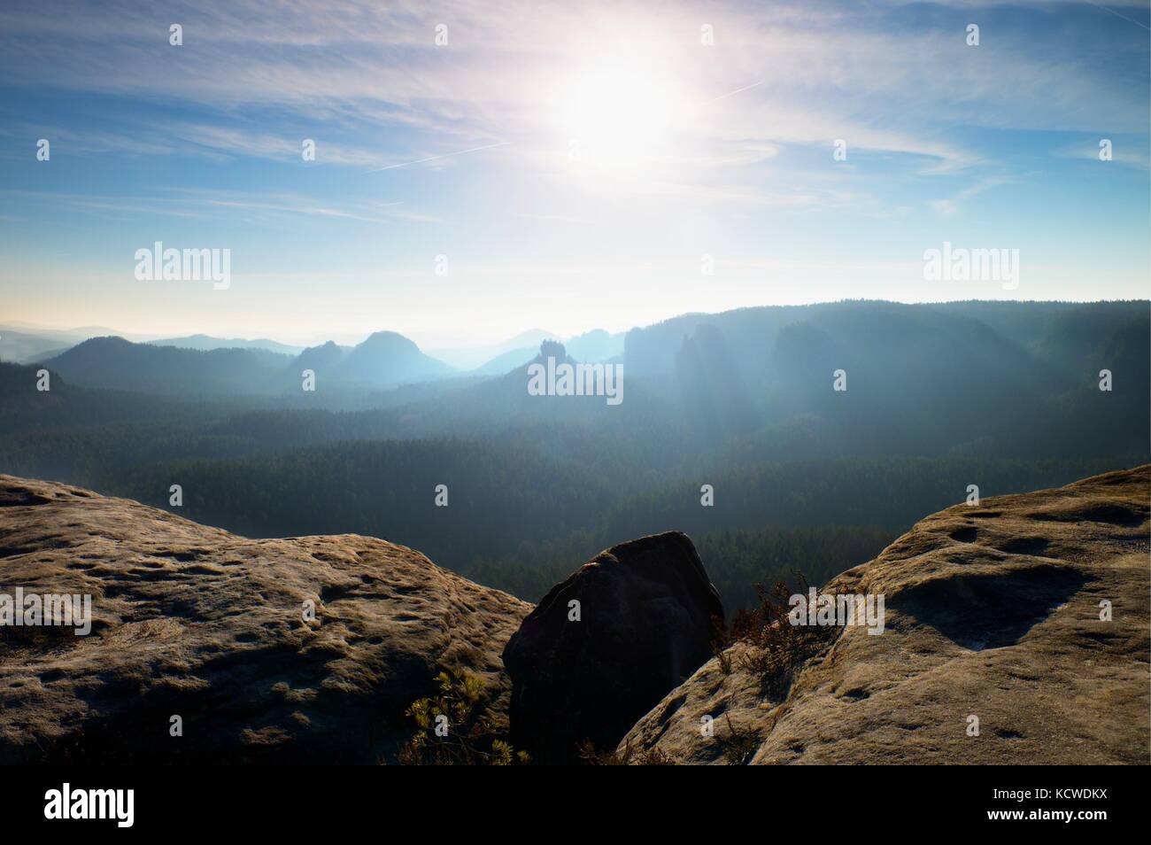 Spring misty morning in forest landscape. Majestic peaks cut lighting ...