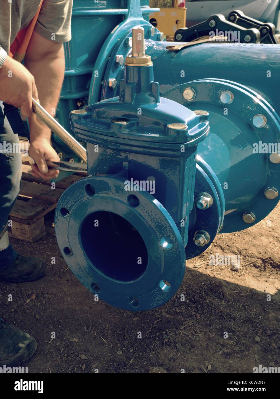 Worker hands with tools screwing nuts on new dring water piping. Piping ...