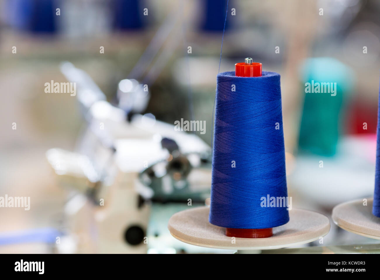 Spools of blue threads on sewing machine closeup. Cloth factory ...