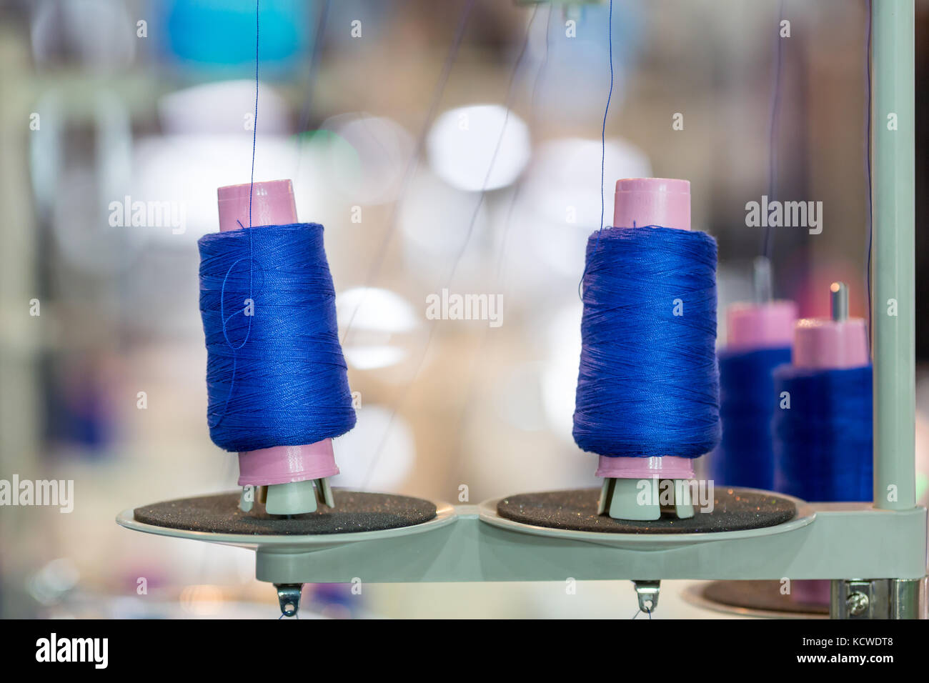 Spools of blue threads on sewing machine closeup. Cloth factory ...