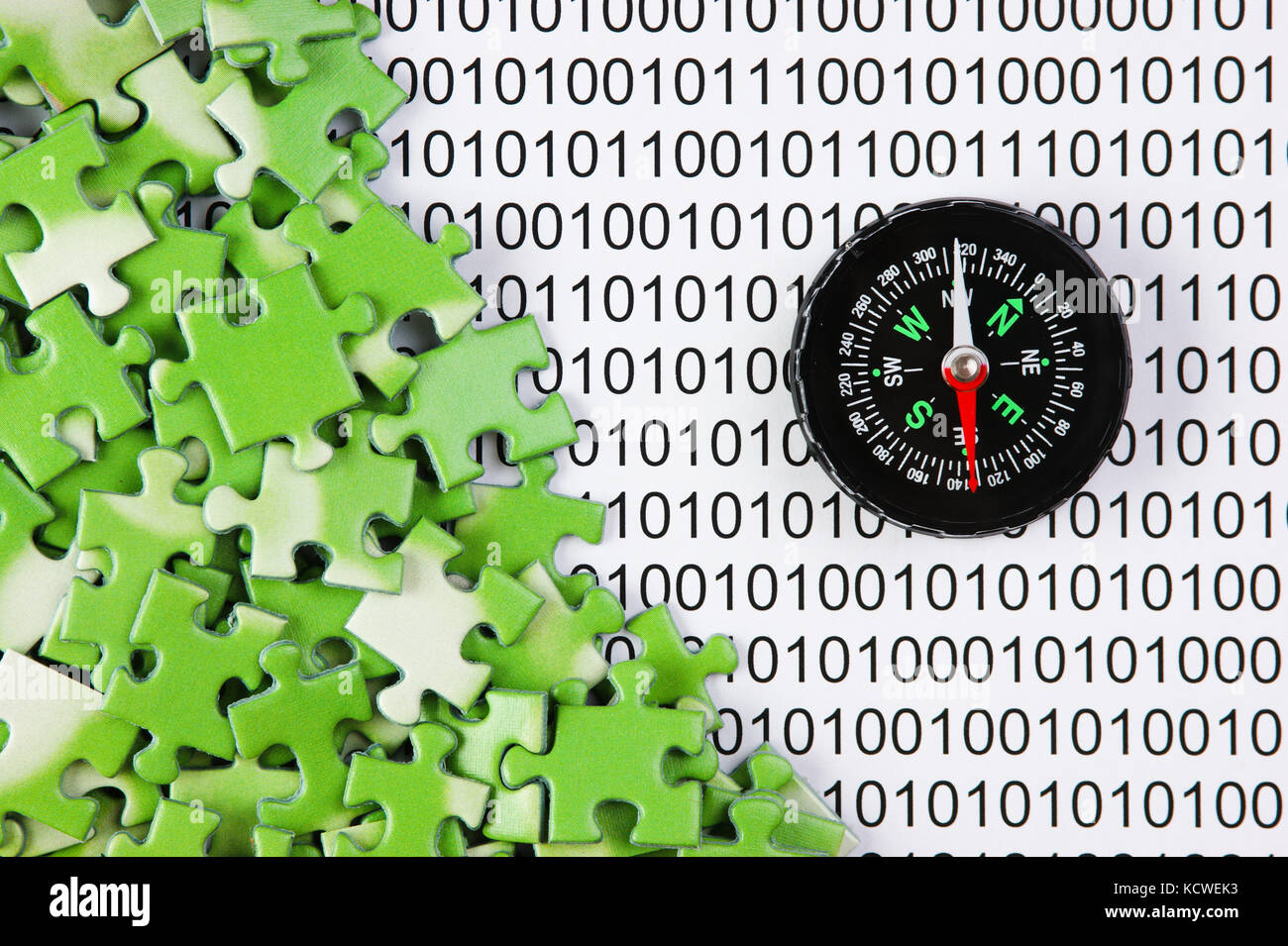 puzzles and compass on a binary code Stock Photo - Alamy