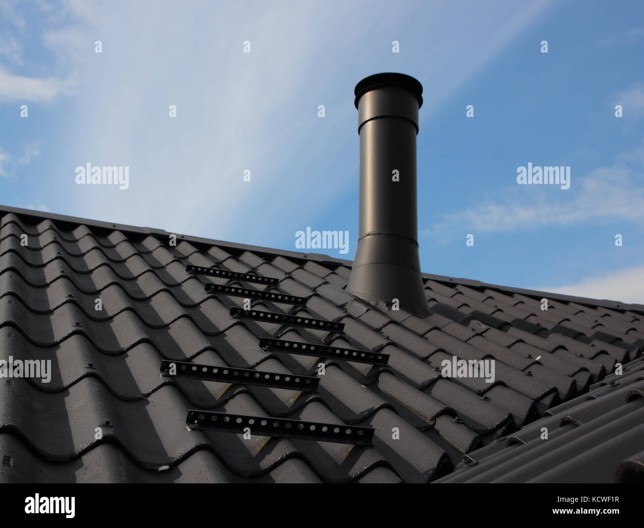 Black Metal Chimney on Roof with Secure Sweeper Steps Stock Photo - Alamy