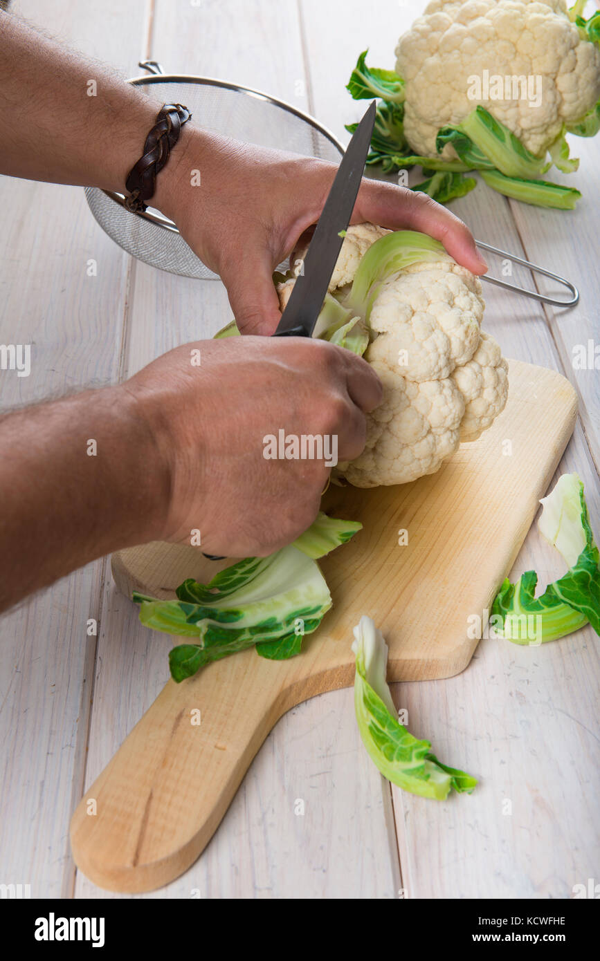 Chef preparing and cleaning a cauliflower to be boiled and cooked Stock ...