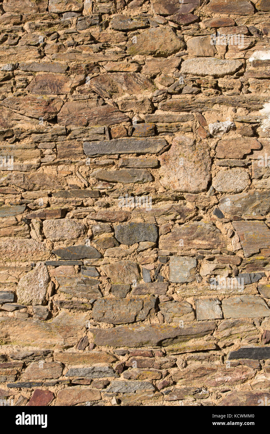 Brownish stone patterns on an old dry stone wall lit by the afternoon ...