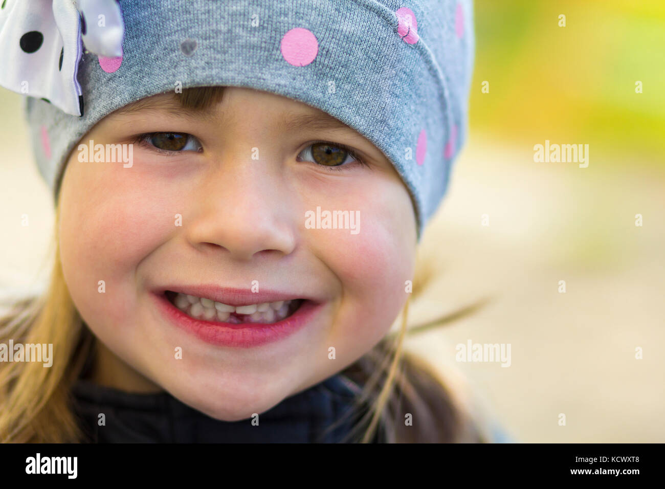 Portrait of pretty smiling little girl with one fallen out milk tooth ...
