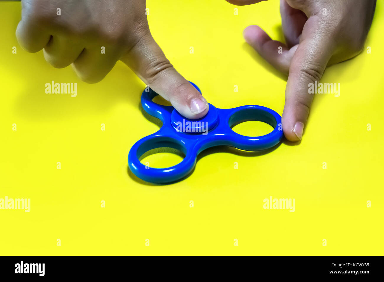 Blue Hand spinner, fidgeting hand toy rotating on child's finger. the ...